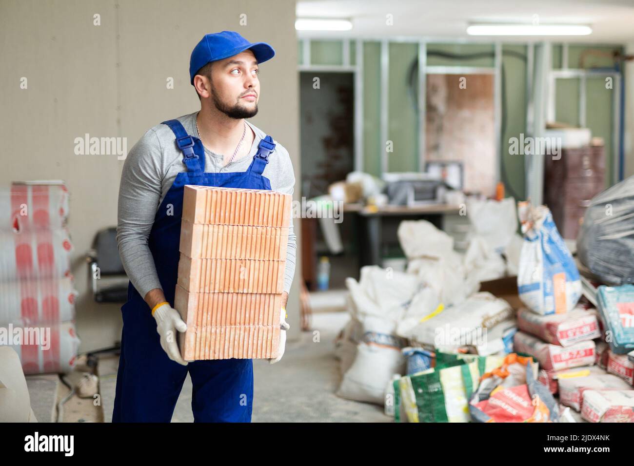 Construction worker carrying bricks at renovating object Stock Photo ...