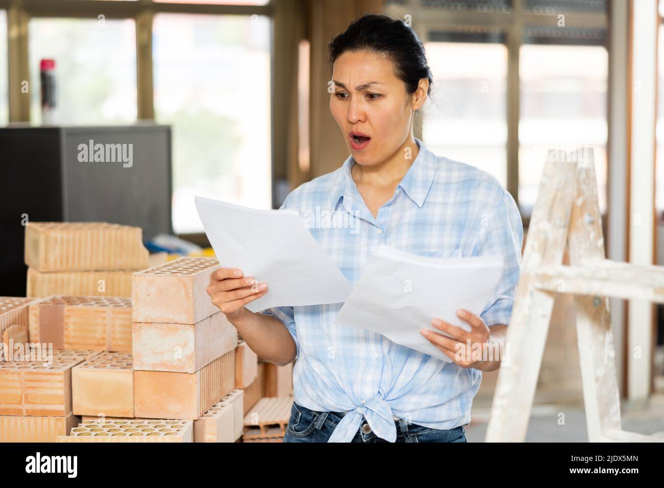 Frustrated woman architect on indoor construction site Stock Photo - Alamy