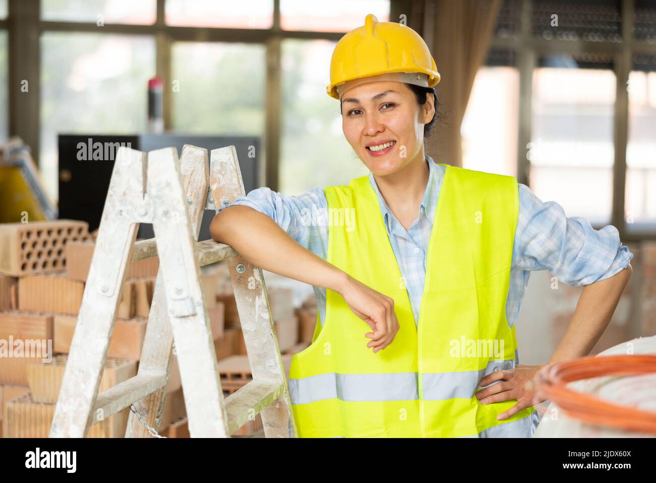 Female builder posing on indoor construction site Stock Photo - Alamy