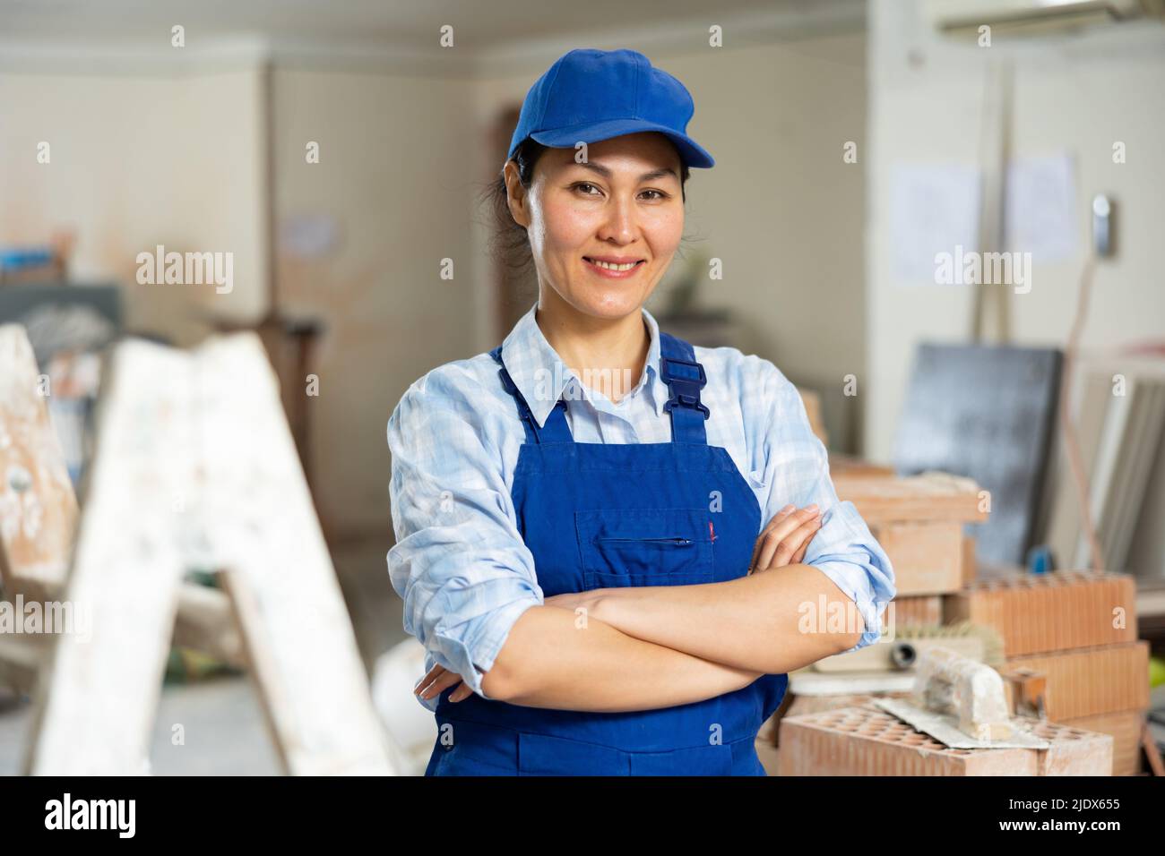Female builder posing on indoor construction site Stock Photo - Alamy