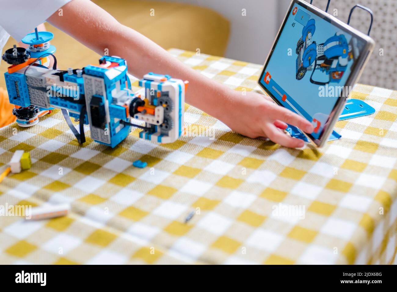 Kid collects robot from plastics details and programmed on tablet ...