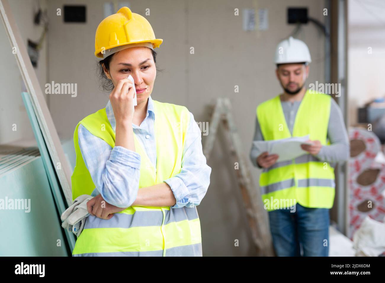 Crying female builder at construction site with displeased foreman ...