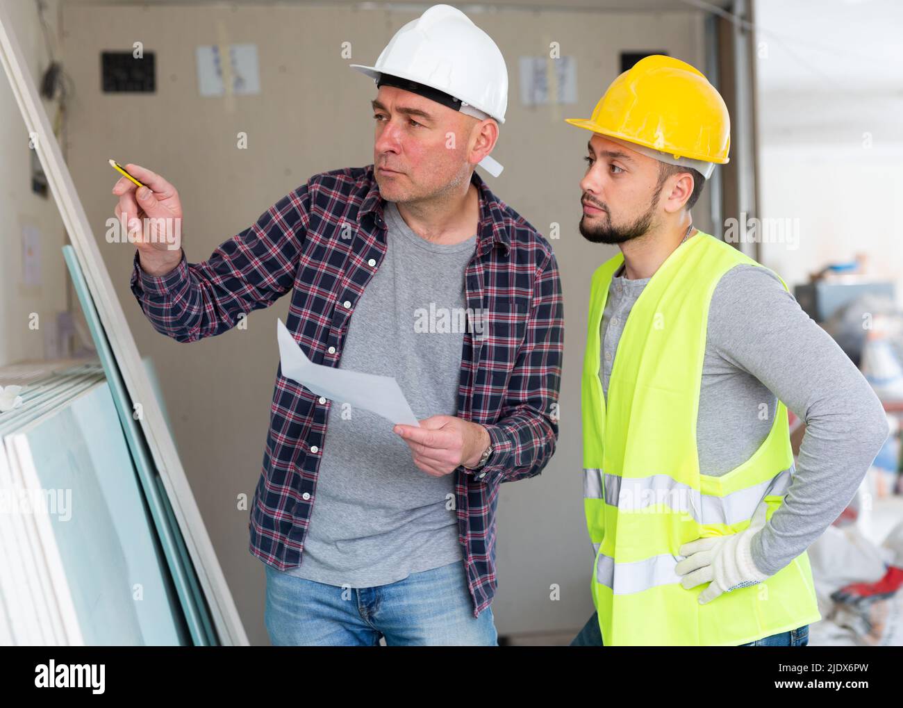 Architect and builder checking documentation in construction site Stock ...