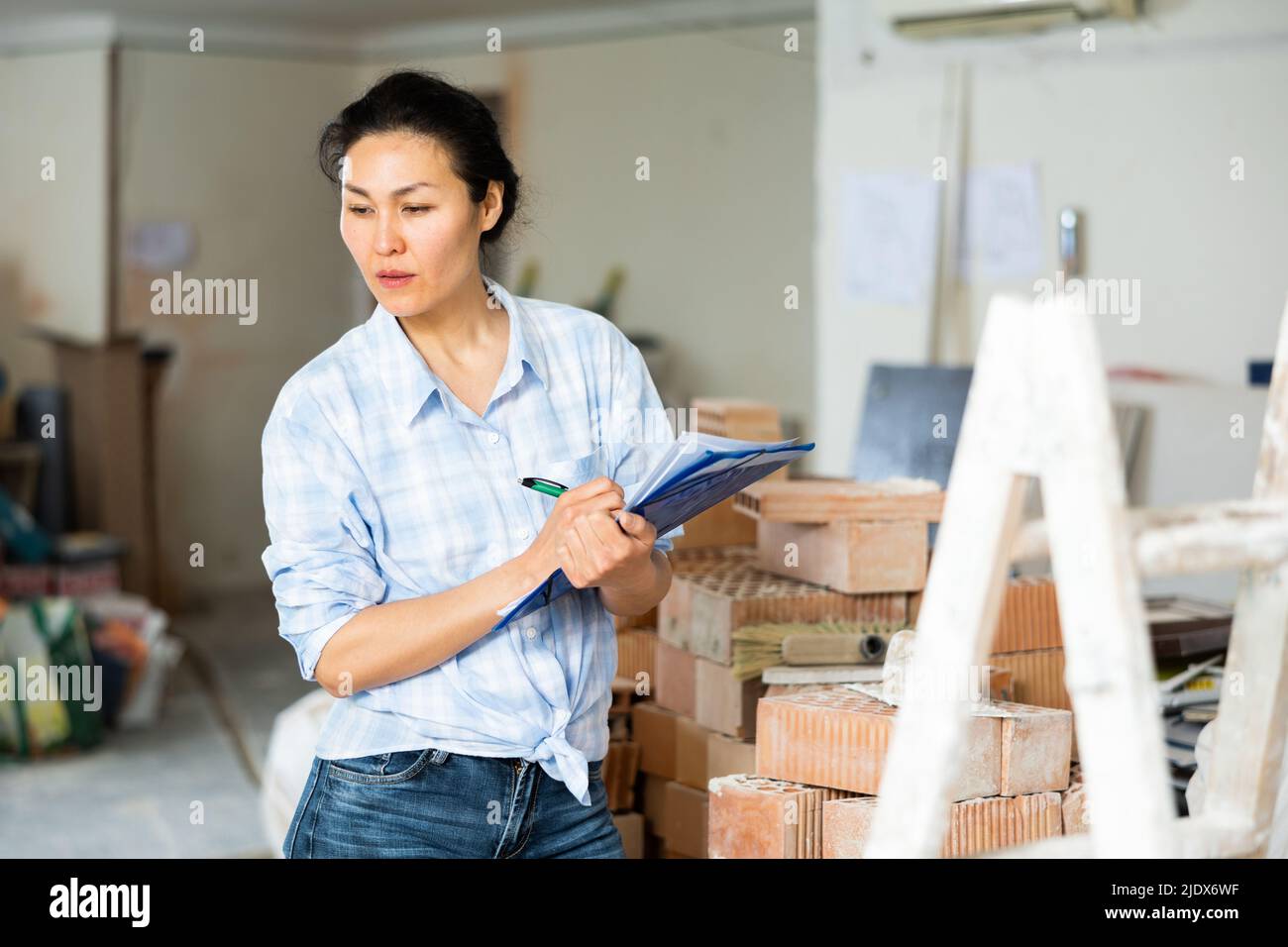 Woman checks the completed construction work on drawing Stock Photo - Alamy