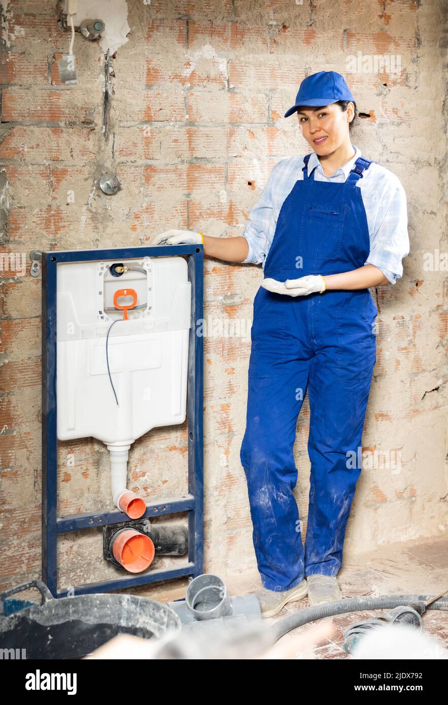 Plumber near mounted on wall toilet system Stock Photo - Alamy