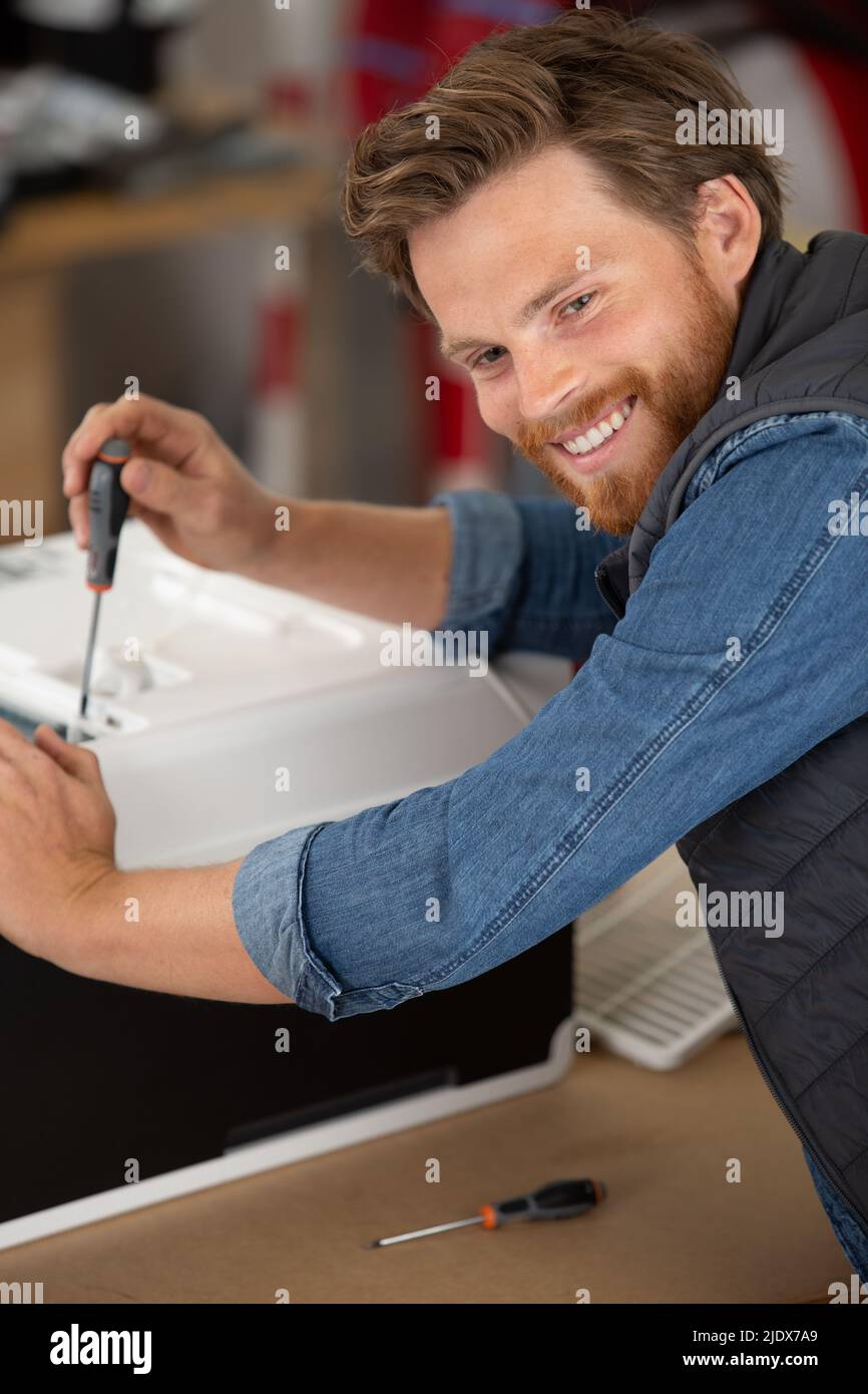 happy young man holding a screwdriver for fixing printer Stock Photo ...