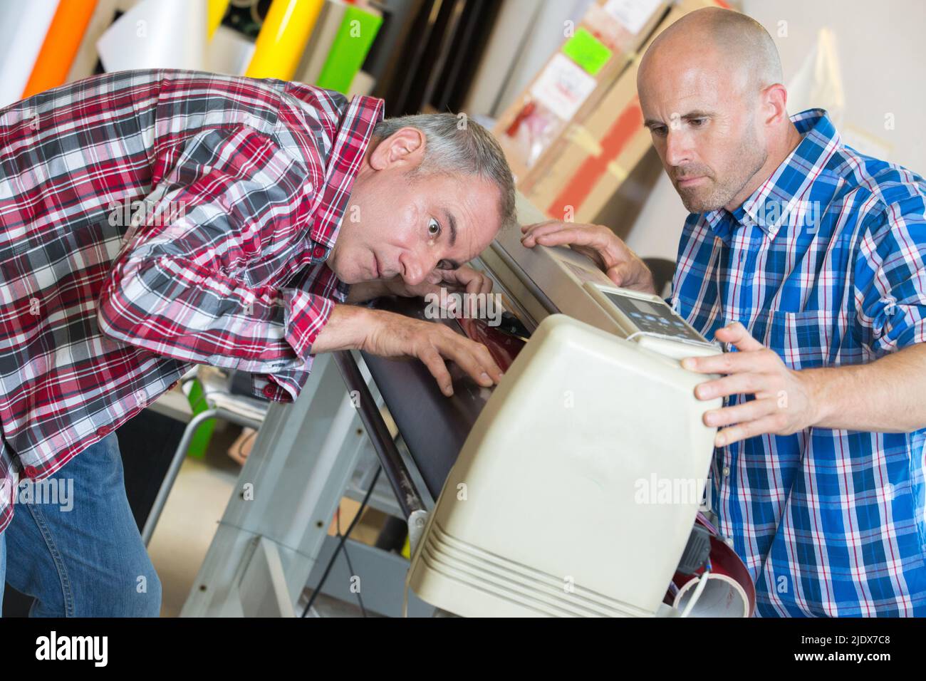 men fixing industrial printing machine Stock Photo - Alamy