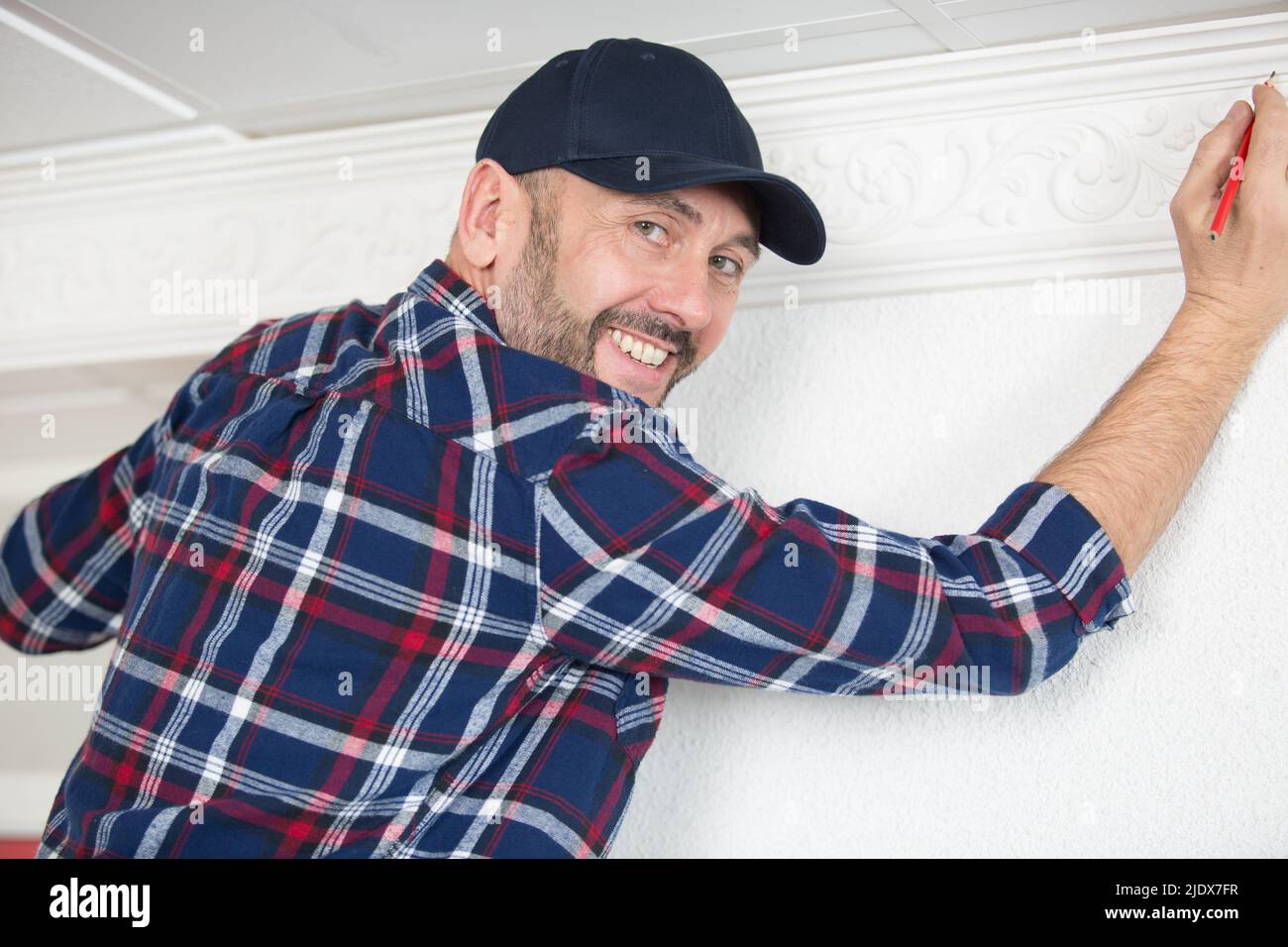happy contractor employee applying plaster on wall Stock Photo - Alamy