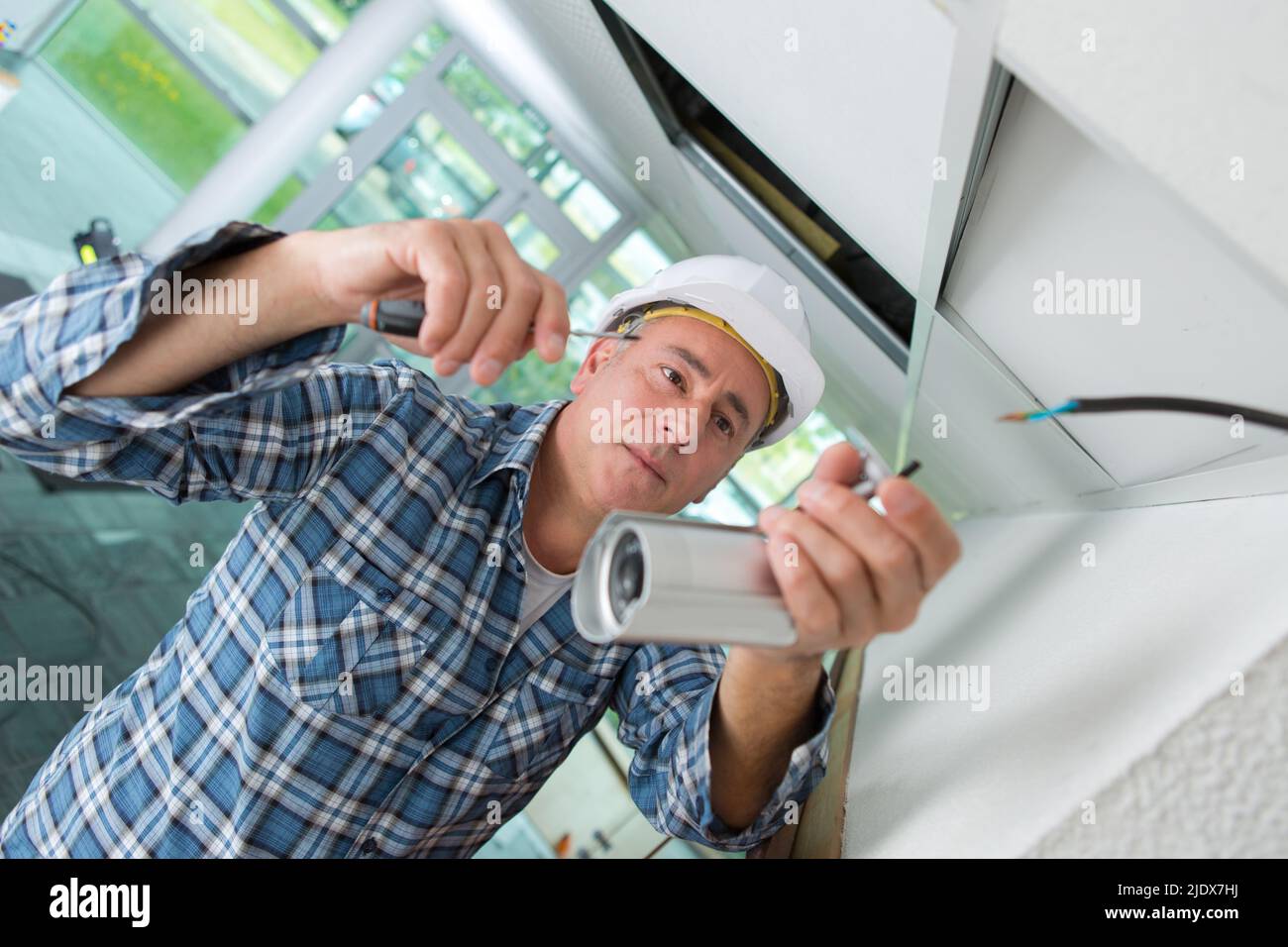 senior electrician connecting cctv camera in office Stock Photo - Alamy
