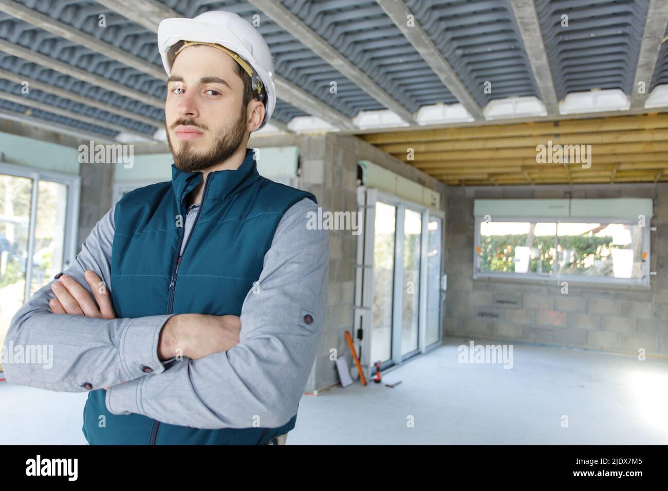 builder with his arms crossed on construction site Stock Photo - Alamy