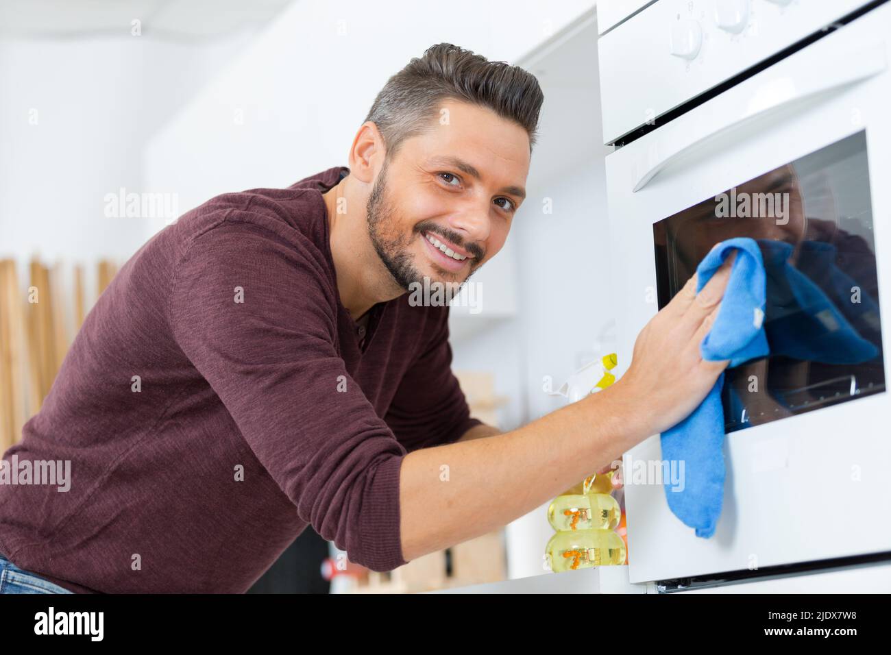 happy man cleaning oven in the kitchen Stock Photo - Alamy