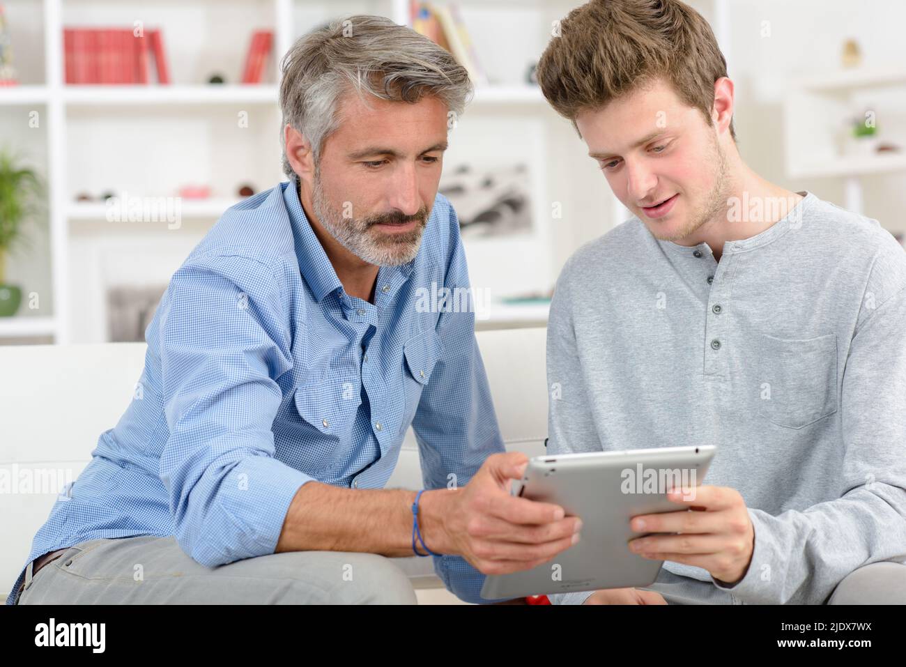 Father son looking tablet screen hi-res stock photography and images ...