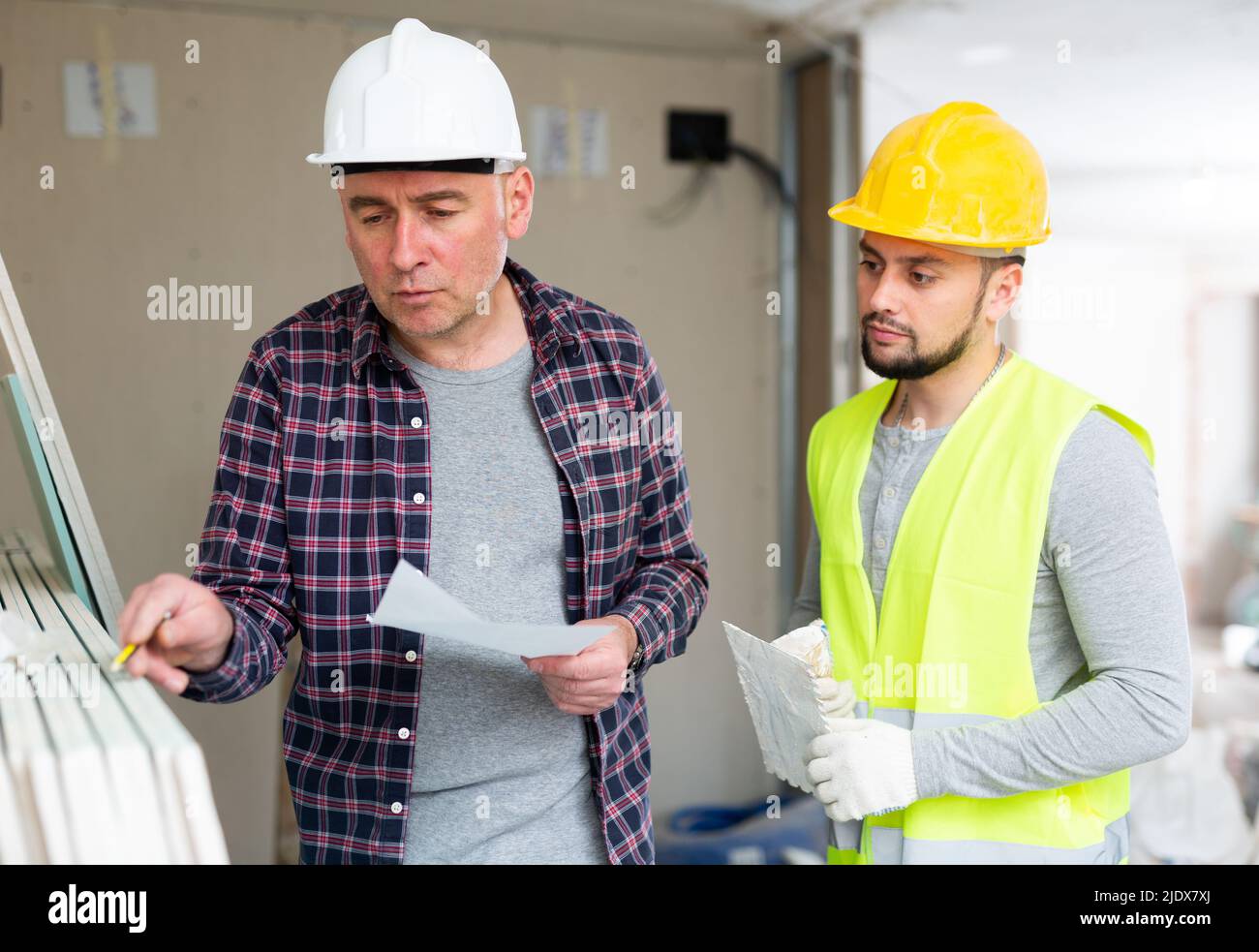 Civil engineer giving instructions to foreman in building under ...