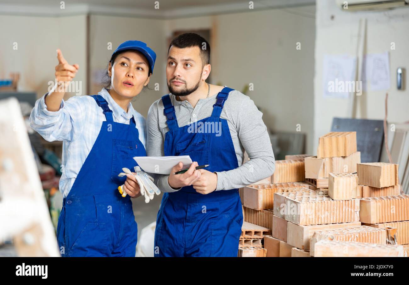 Builders determining scope of work in building under renovation Stock ...