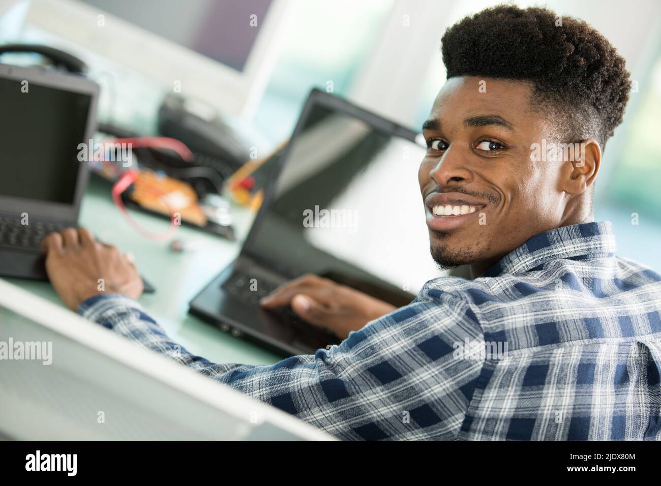 portrait of a male computer engineer using two laptops Stock Photo - Alamy