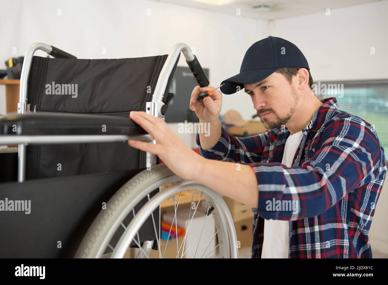 handyman maintening a wheelchair in the workshop Stock Photo - Alamy