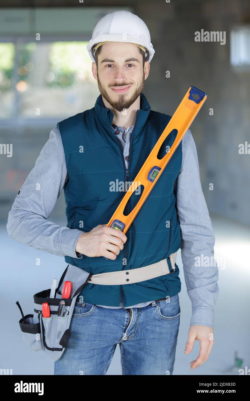 Smiling bricklayer holding level tool hi-res stock photography and ...