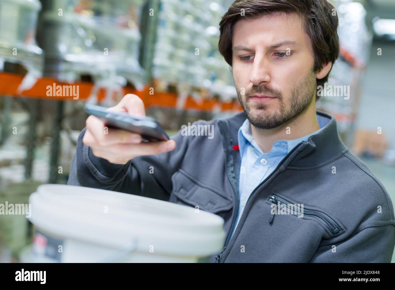 storeman scanning code on container with smartphone Stock Photo - Alamy