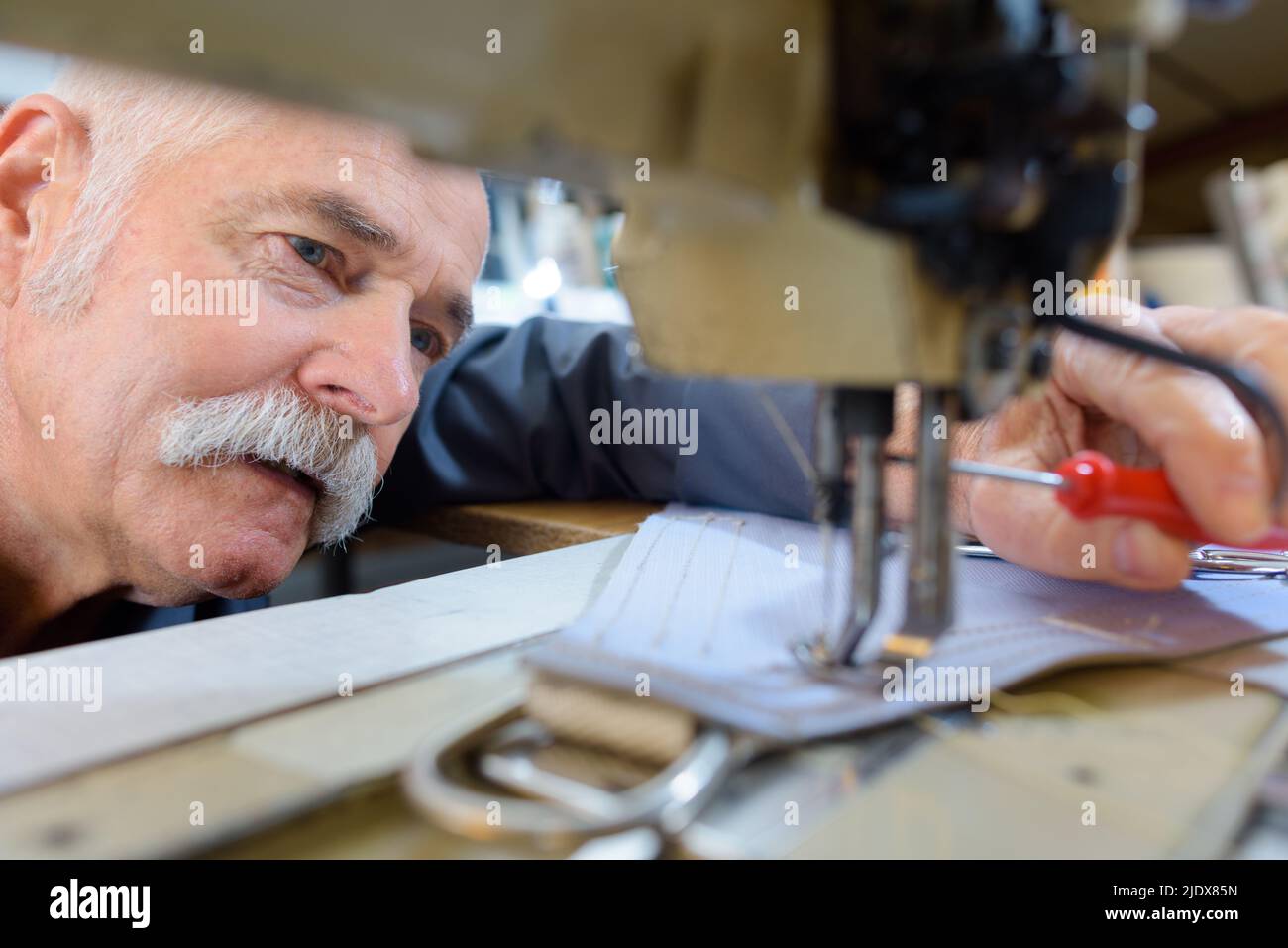 senior workman sewing on stitch lathe Stock Photo - Alamy