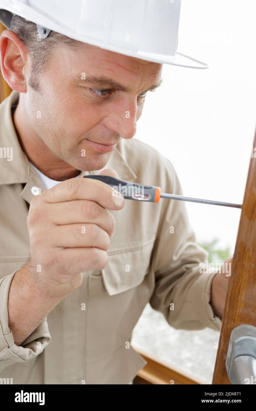a locksmith repairs handle lock Stock Photo - Alamy