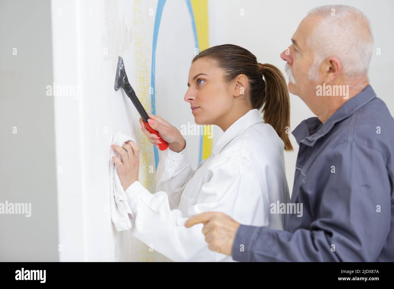 supervisor showing female trainee decorator how to use scraper Stock ...