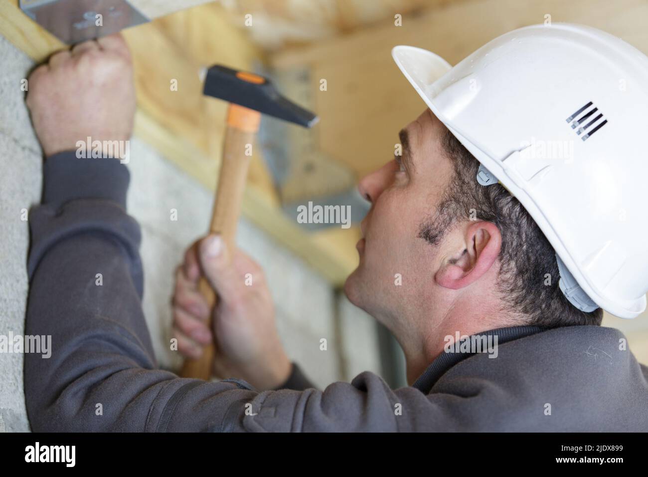 carpenter working on roof structure on construction site Stock Photo ...