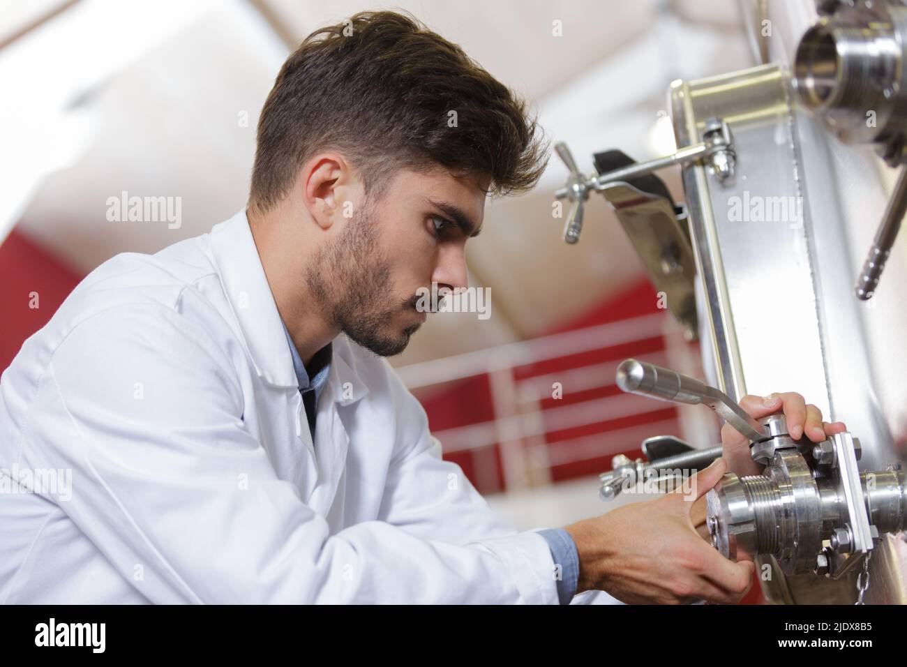 industrial factory worker turning valve Stock Photo - Alamy