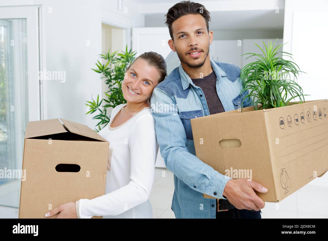 couple posing while carrying box Stock Photo - Alamy