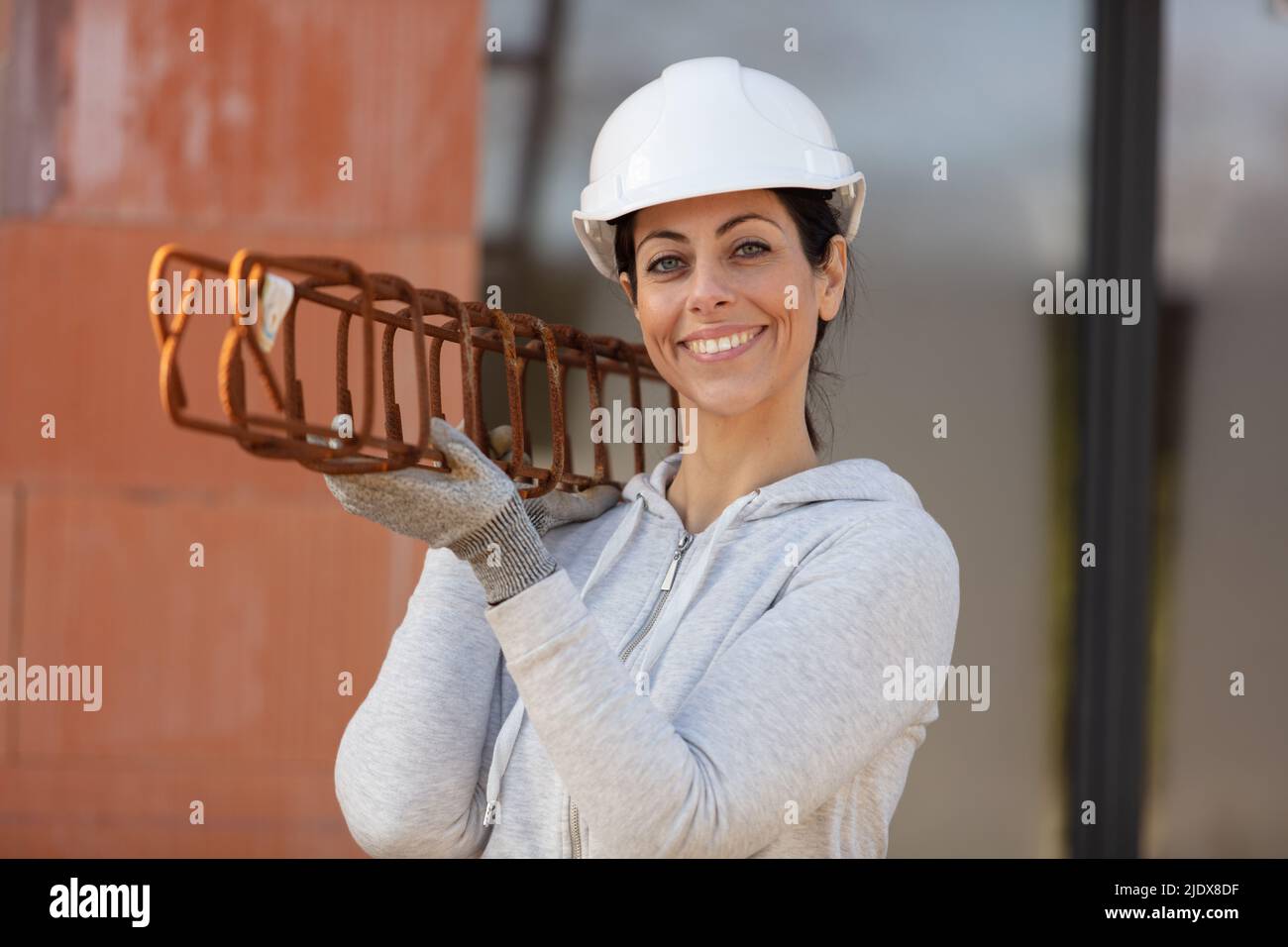 woman builder carrying a steel bar for construction Stock Photo - Alamy