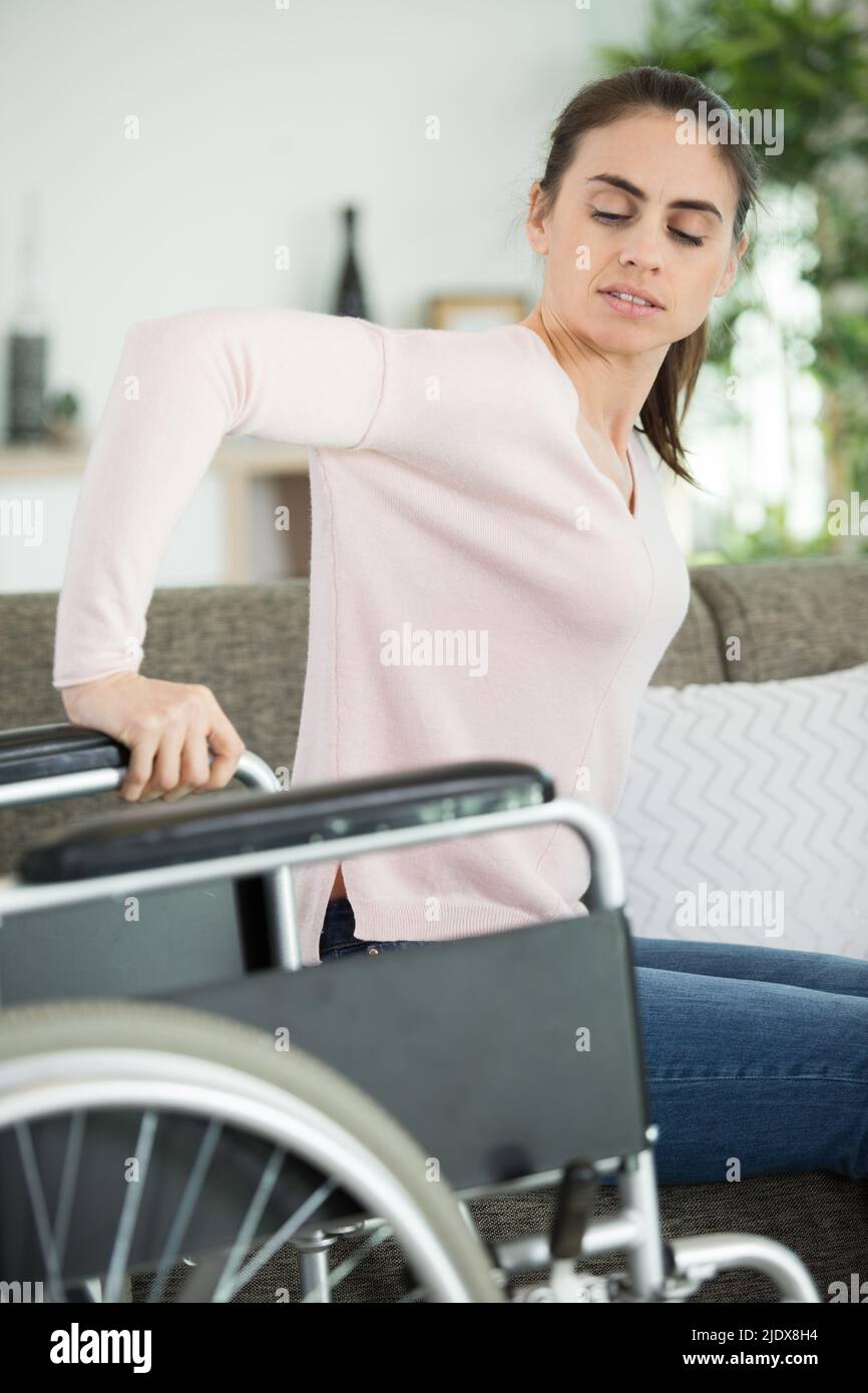 disabled woman trying to sit on wheelchair Stock Photo - Alamy