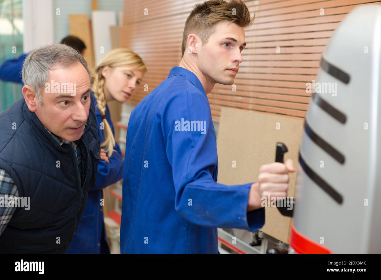 wood processing apprentice operating a machine Stock Photo - Alamy