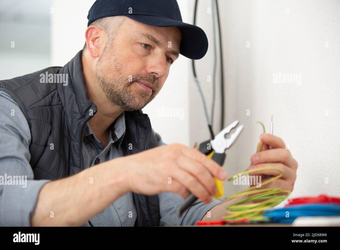 electrician cutting wires against black Stock Photo - Alamy