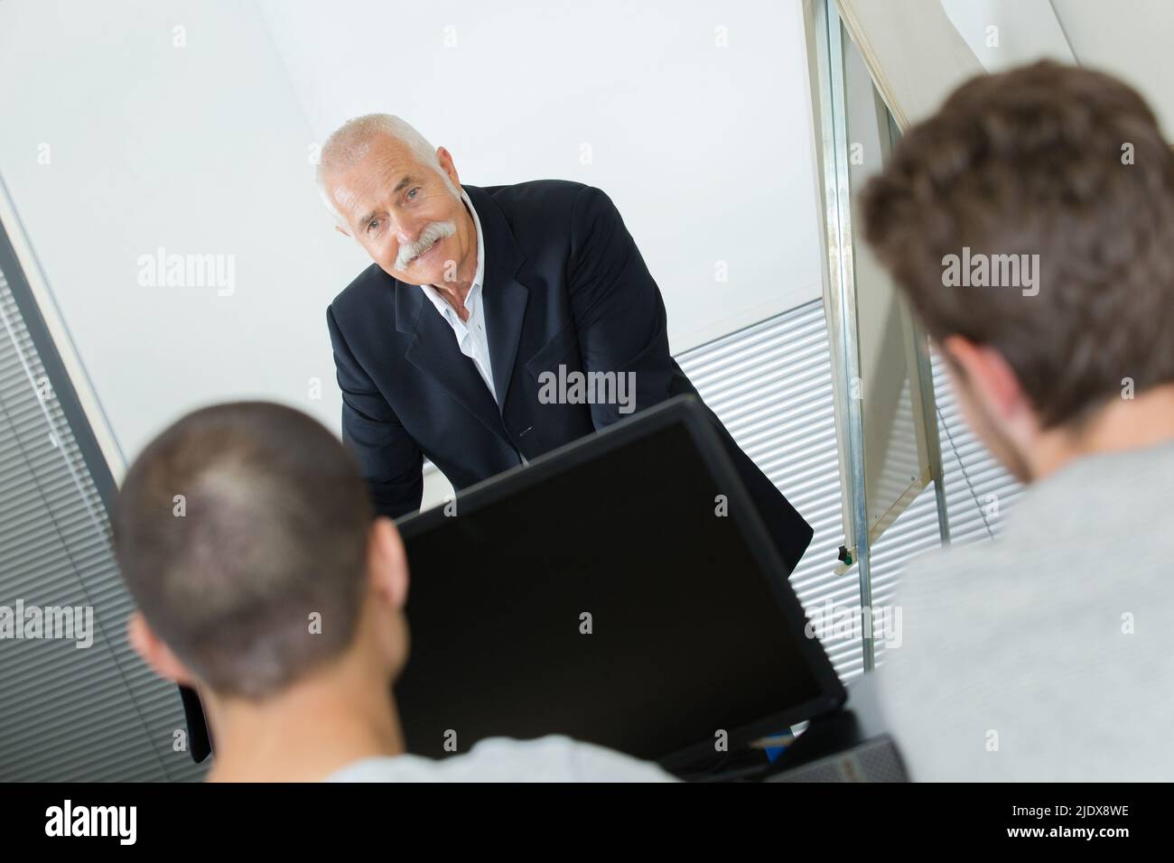 senior man giving presentation to male students Stock Photo - Alamy