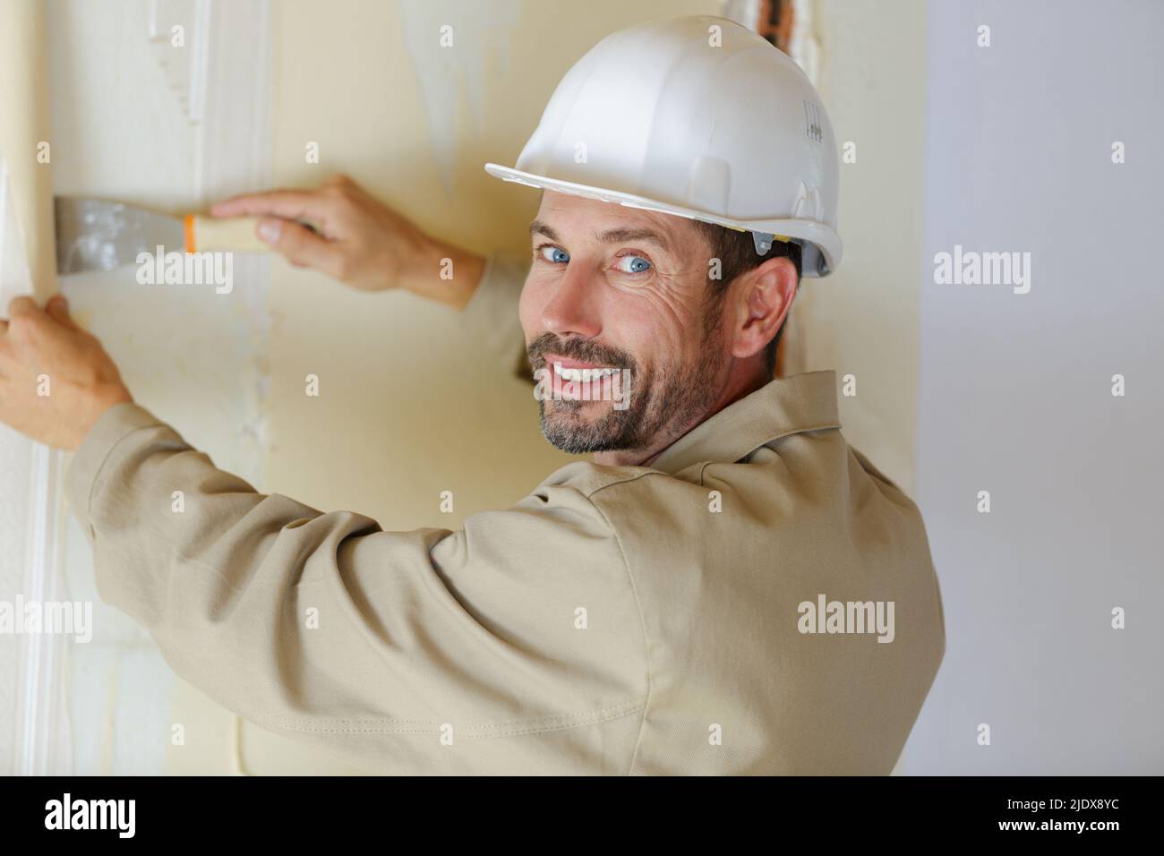 a builder pulling wall paper Stock Photo - Alamy