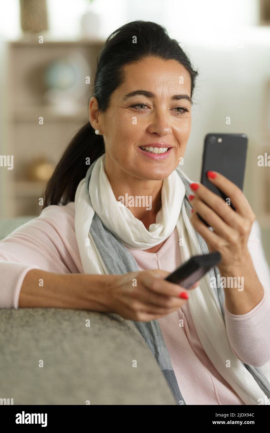 woman texting while she is sat on a couch Stock Photo - Alamy