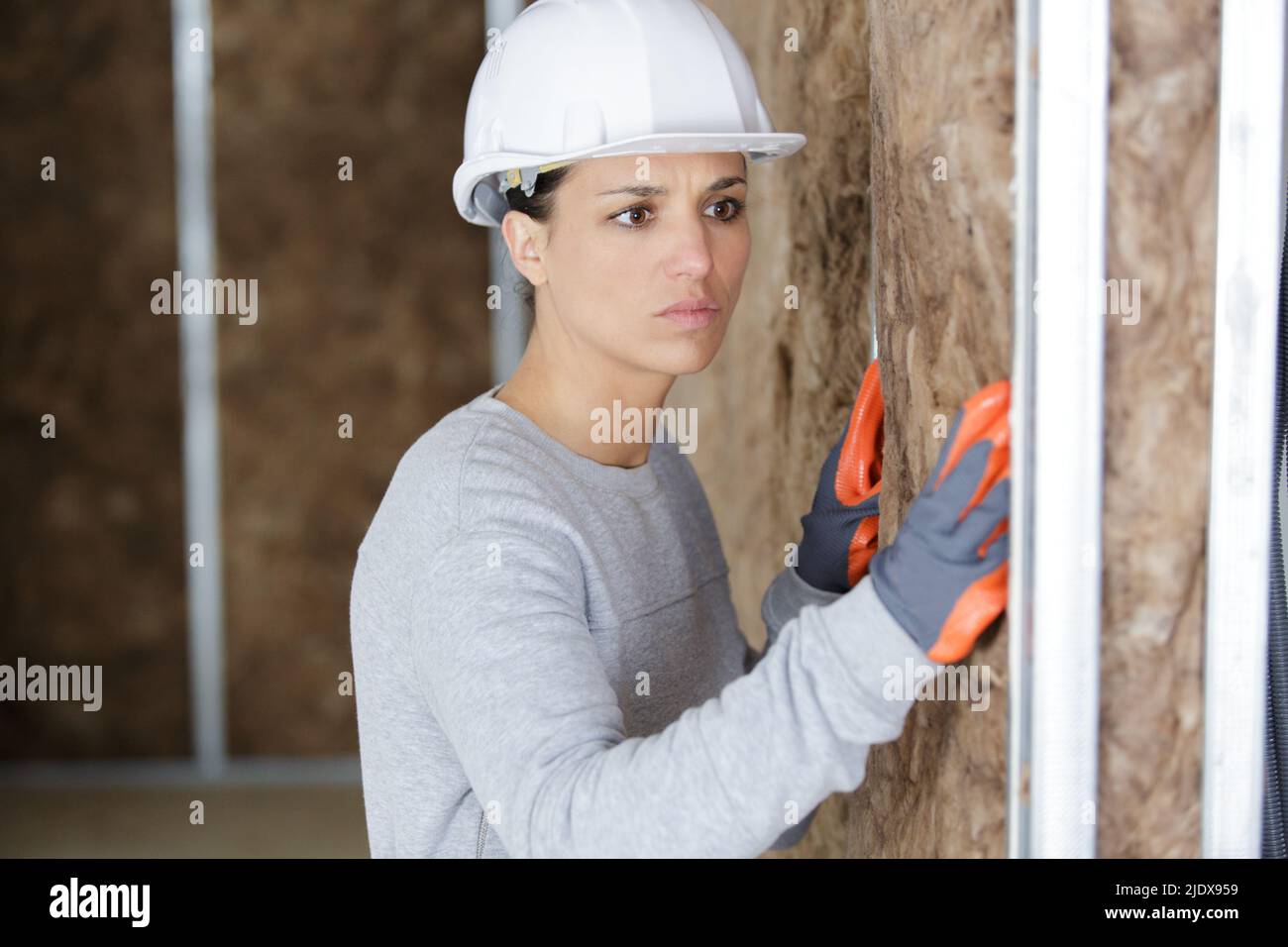 female worker at a indoors wall insulation works Stock Photo - Alamy
