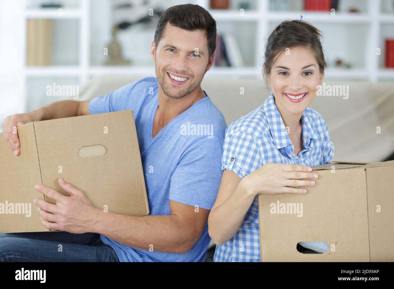 portrait of smiling couple unloading boxes Stock Photo - Alamy