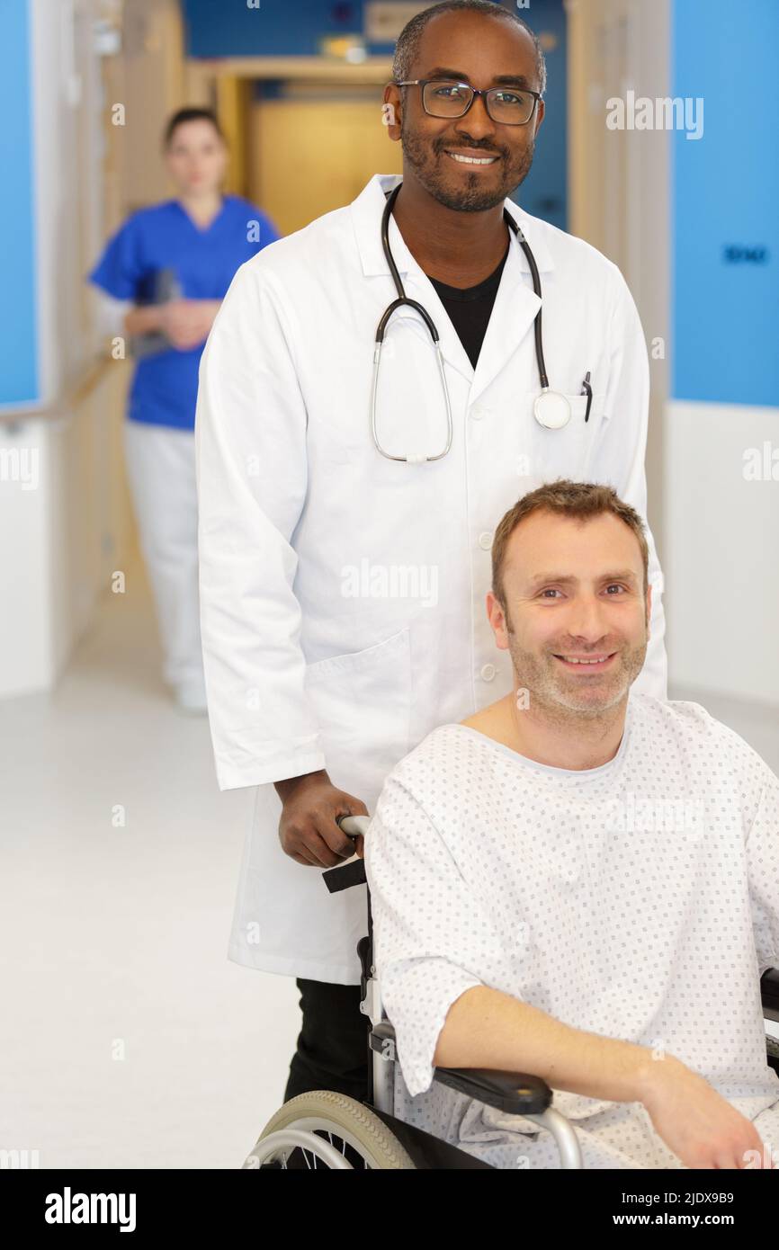 doctor pushing patient in wheelchair in hospital corridor Stock Photo ...