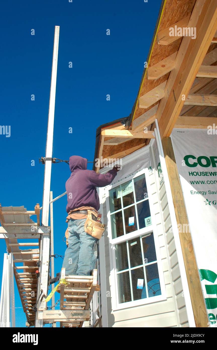 crew Installing Vinyl Siding on outside of a new home construction in ...