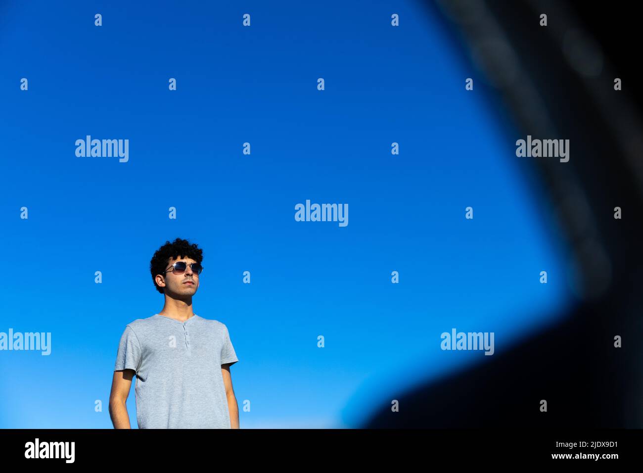latin influencer boy in a nice summer portrait on a big blue background ...