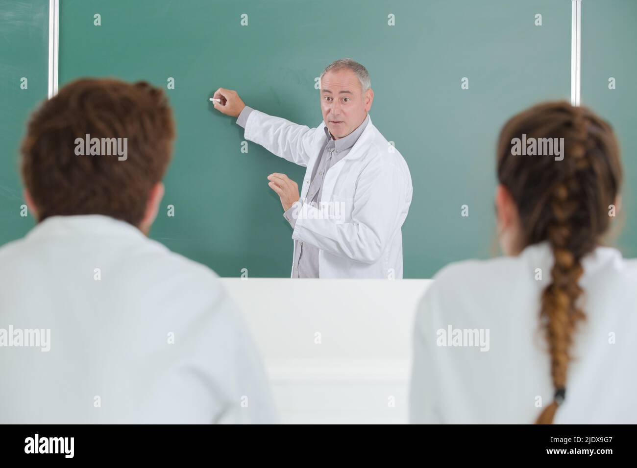 a teacher at a blackboard Stock Photo - Alamy