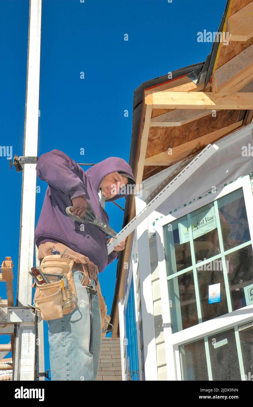crew Installing Vinyl Siding on outside of a new home construction in ...