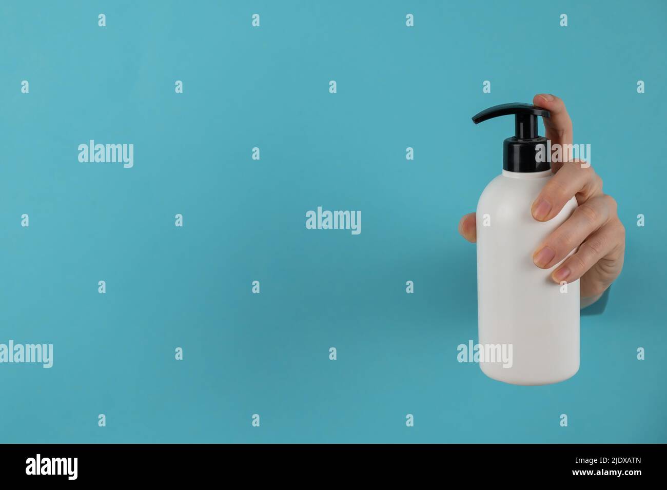 A woman's hand sticks out of a hole in a blue paper background and ...