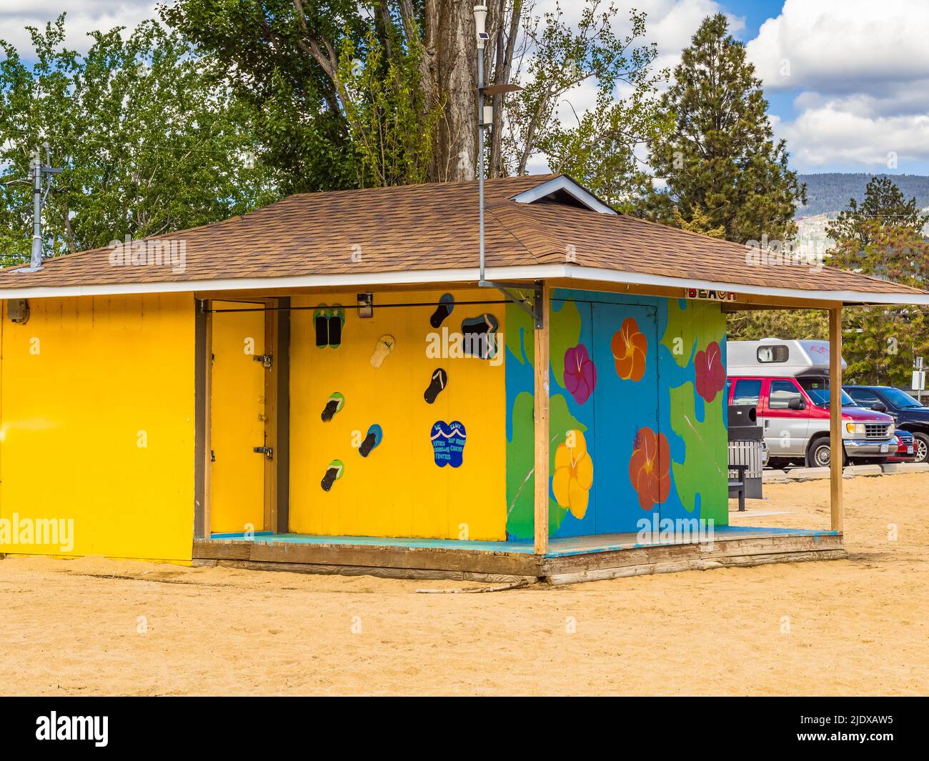 Brightly-coloured beach cabin on beach. Wooden yellow hut on the beach ...