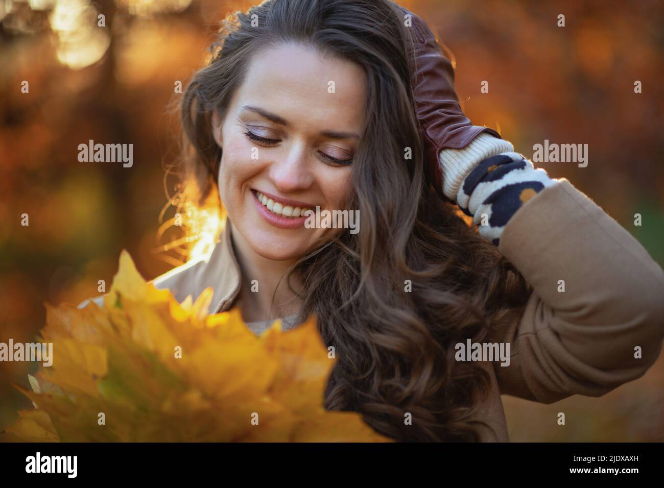 Hello october. smiling modern woman in brown coat with autumn yellow ...