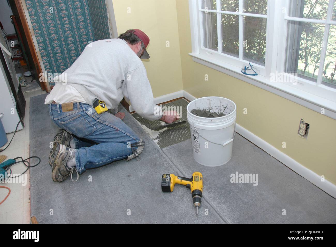 Do it yourself home owner Putting down underflooring and mastic and ...