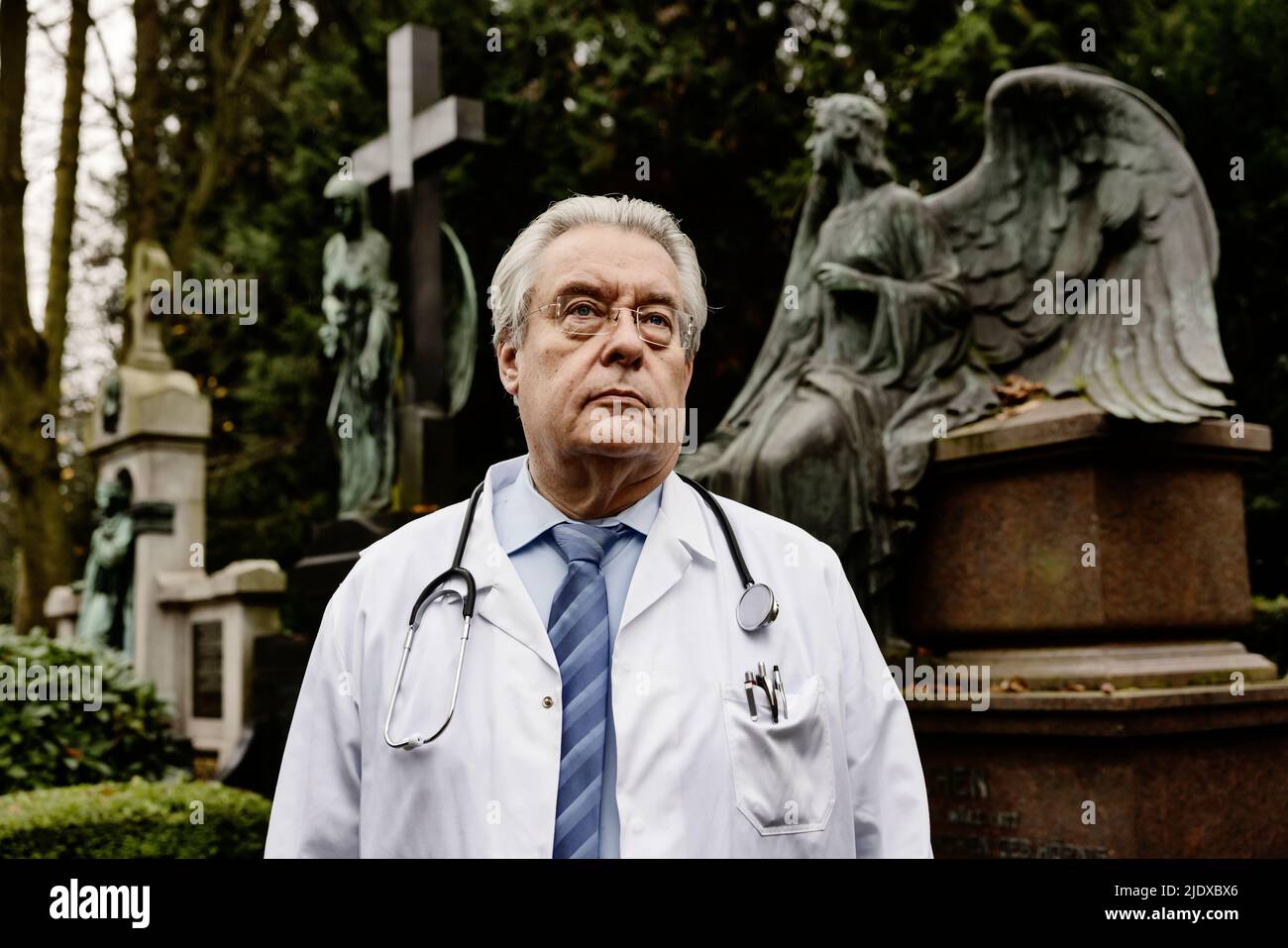 Senior doctor with stethoscope standing on cemetery Stock Photo - Alamy