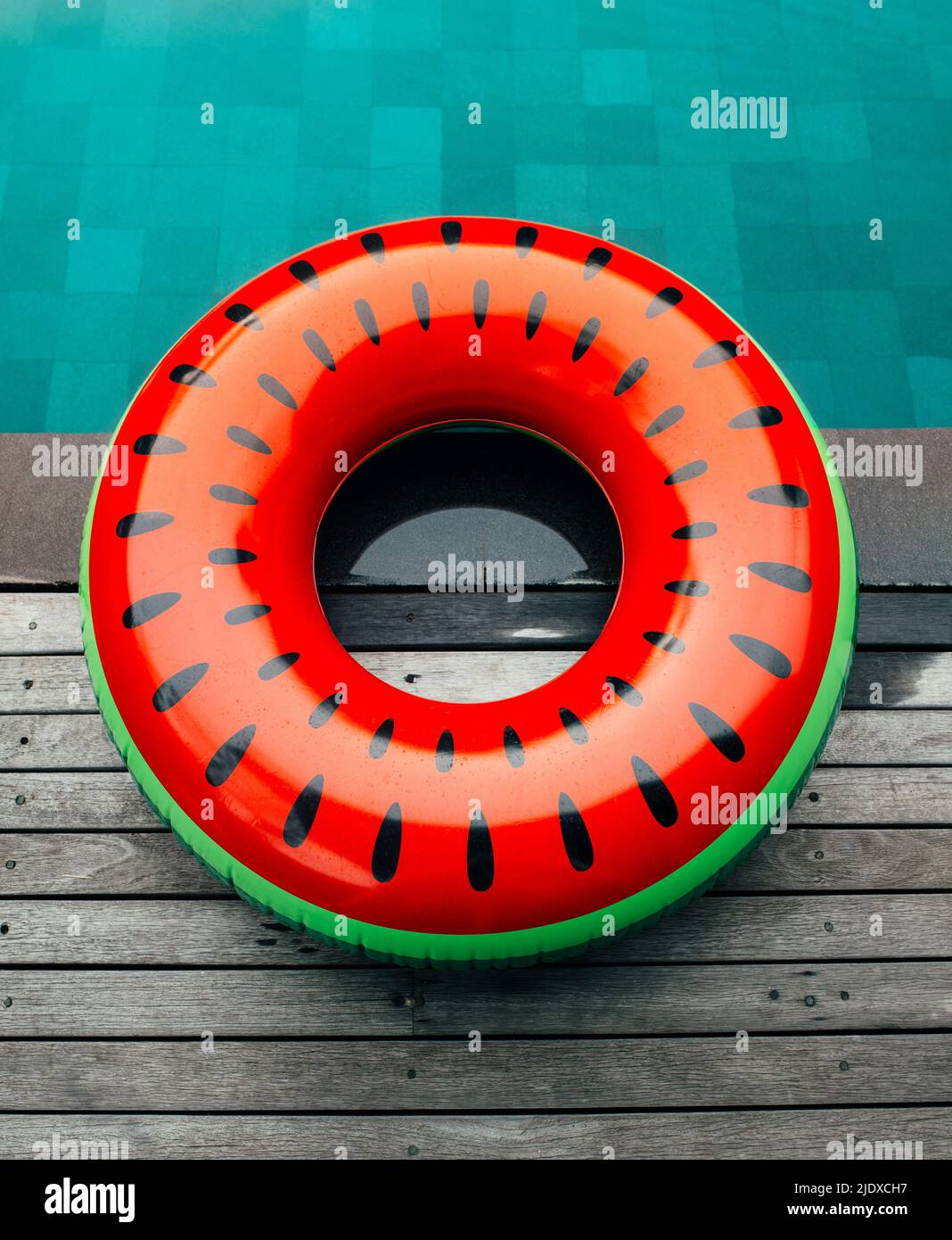 Watermelon shaped inflatable ring lying on edge of swimming pool Stock ...