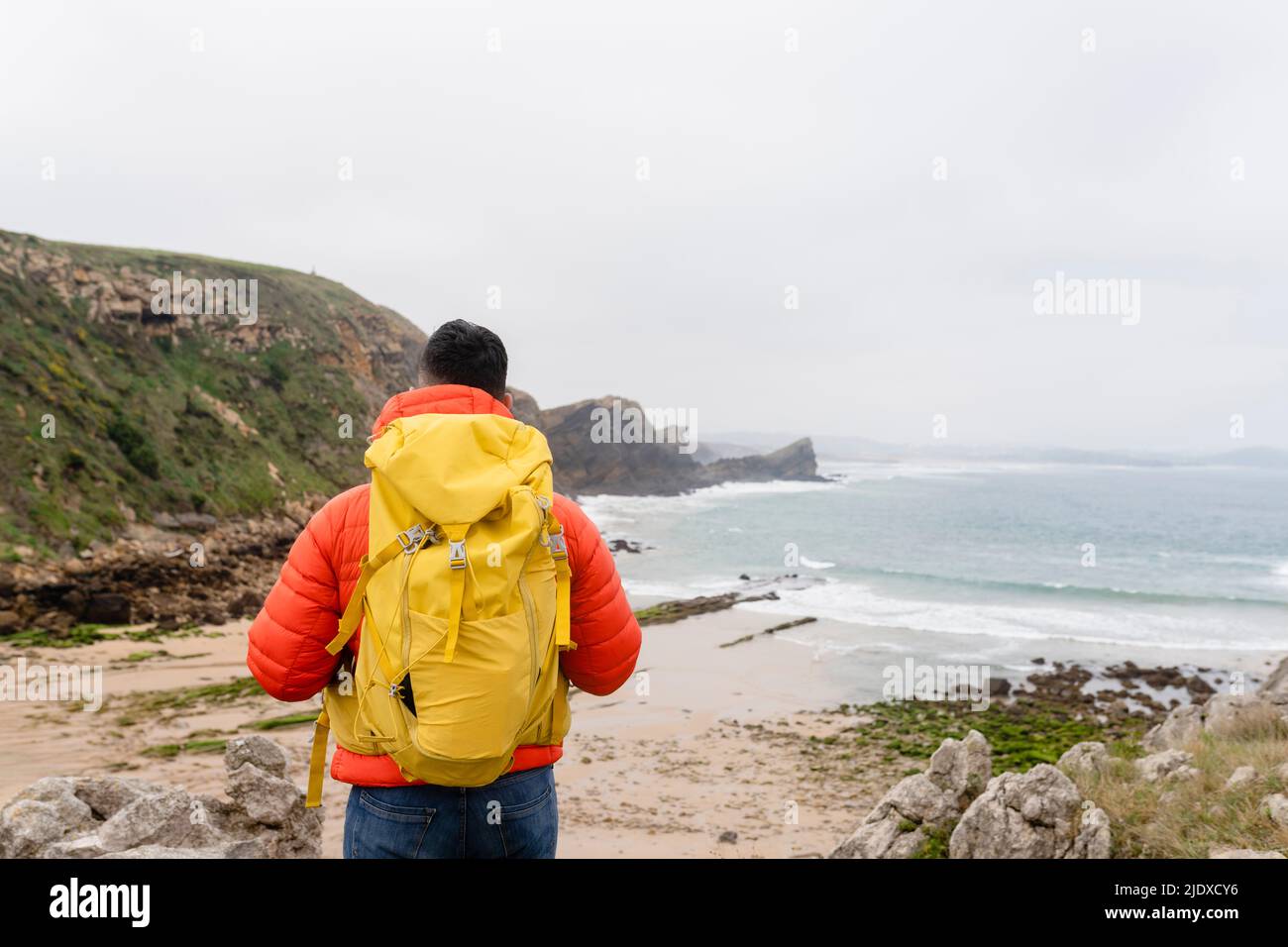 Man wearing backpack looking at view Stock Photo - Alamy