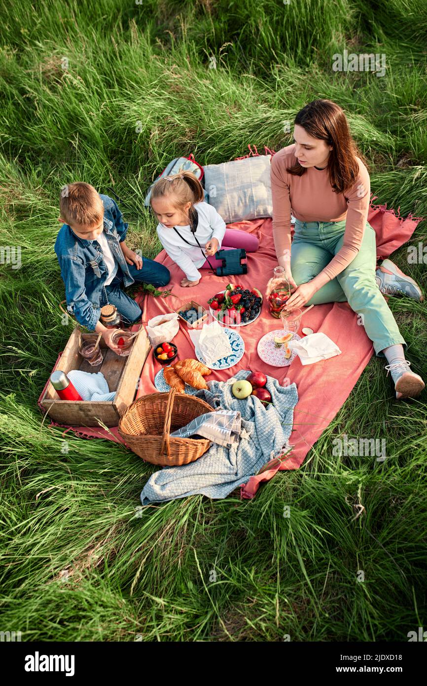Mother and children having food in field on weekend Stock Photo - Alamy